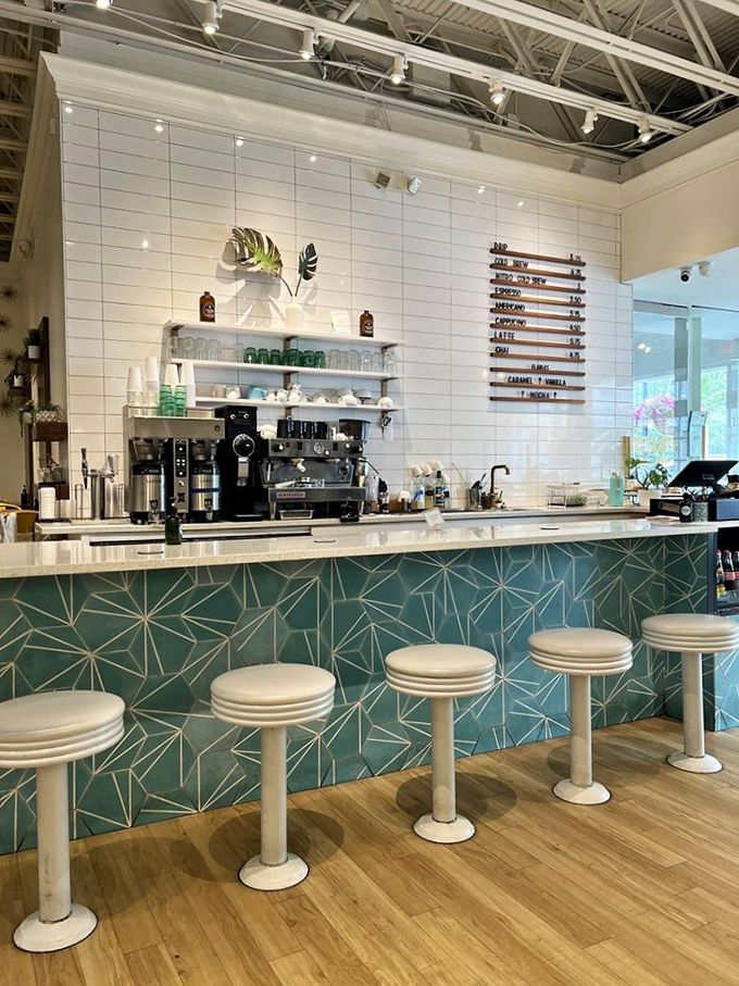 The geometric blue tiles and sleek white counter create a coffee bar that makes ordering a simple latte feel like a special occasion.