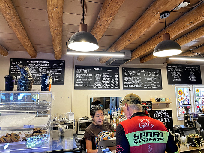 Coffee command center. The staff orchestrates caffeinated joy beneath rustic beams while customers eagerly await their turn at the pastry case.