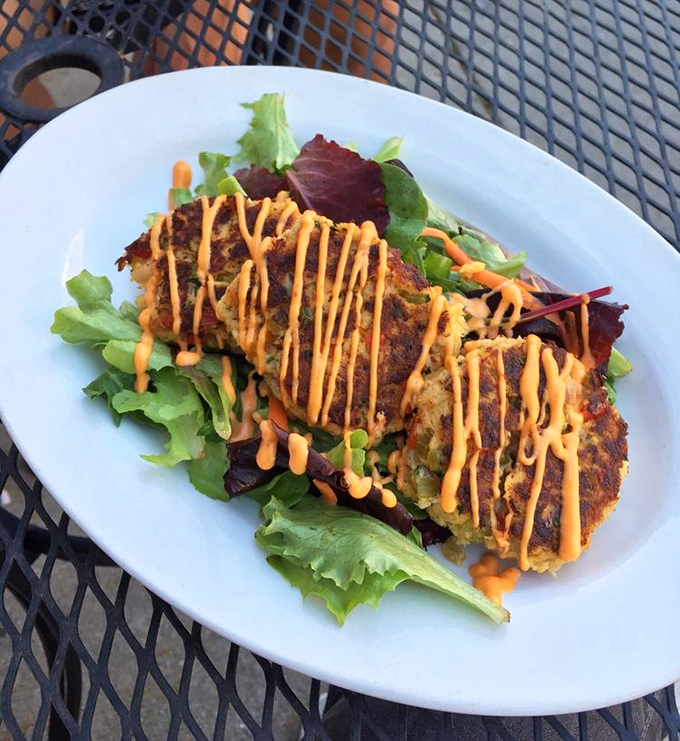 These crab cakes aren't just golden, they're practically glowing with pride, drizzled with sauce that adds just the right kick to each bite.