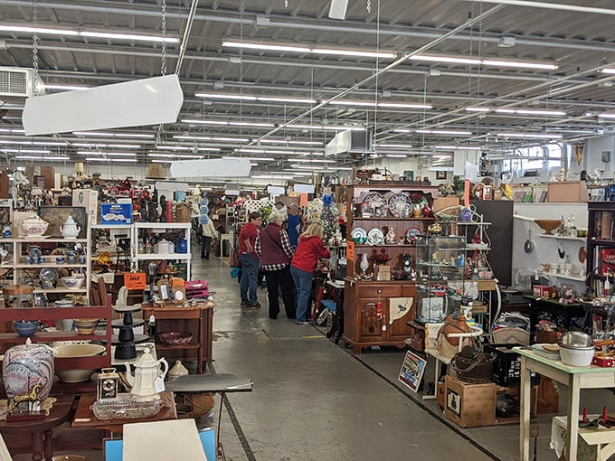 The universal antique mall pose: shoppers leaning in for closer inspection, wondering if that dish matches grandma's set or completes their collection.