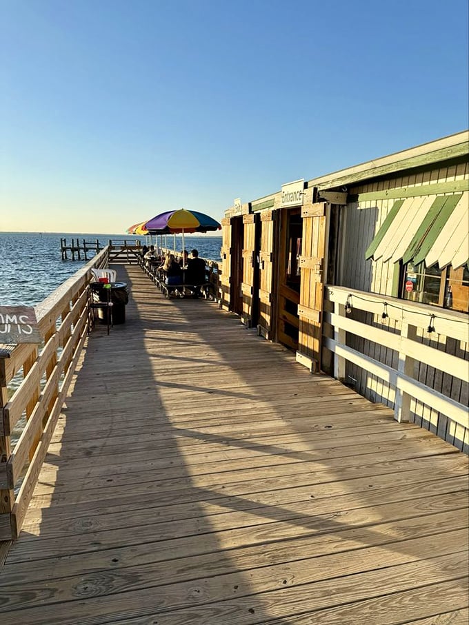 A weathered dock that's seen thousands of perfect evenings. Those colorful umbrellas aren't just shade &ndash; they're beacons guiding hungry souls to seafood nirvana.