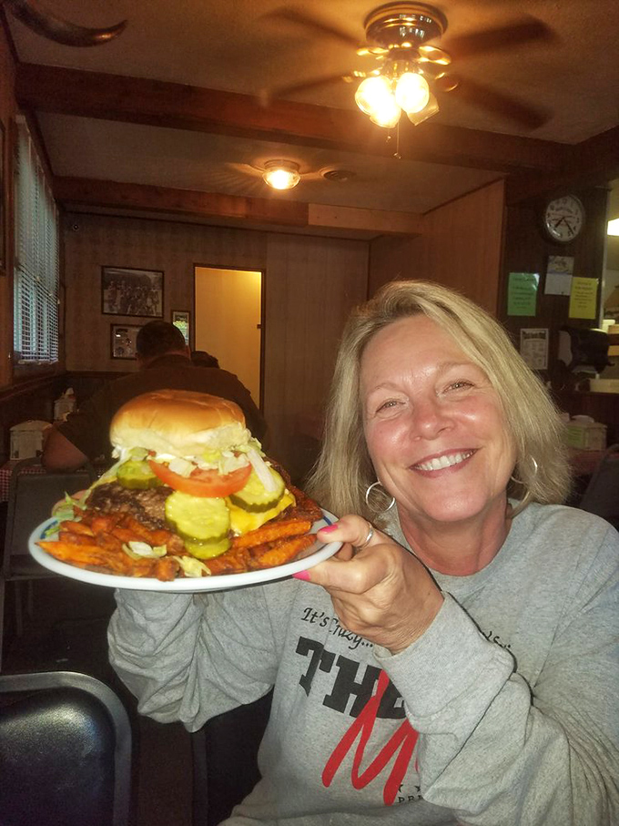 The dining room whispers stories of decades of satisfied customers, while ceiling fans gently circulate the intoxicating aroma of grilling burgers.