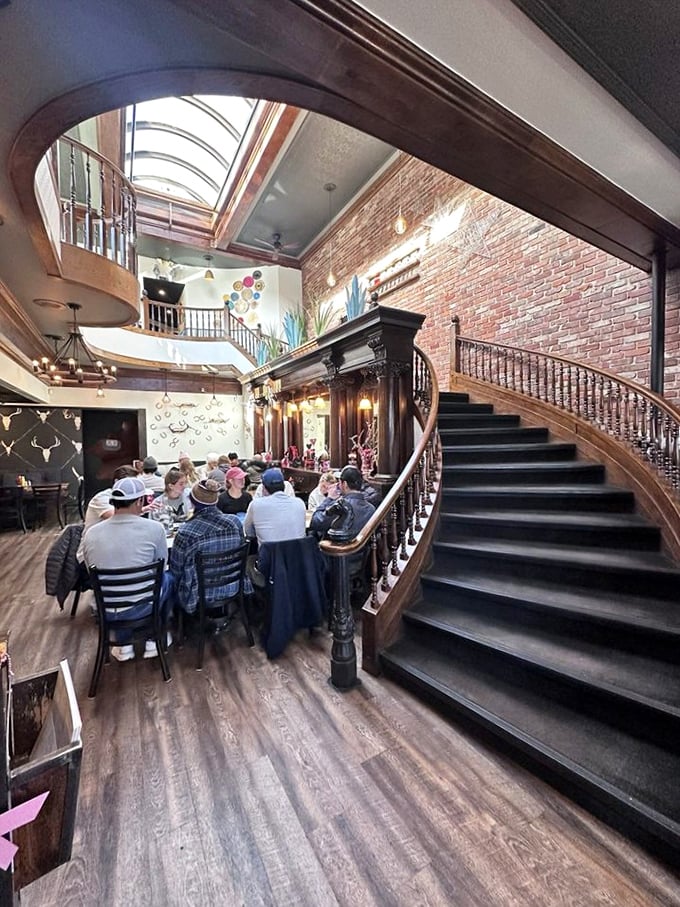 The curved staircase watches over diners like a proud parent. Everyone looks happier than people waiting for tax refunds.
