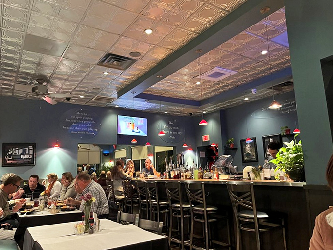 The bar area buzzes with conversation and clinking glasses. Those red pendant lights cast a glow that makes everyone look like they're having the best time of their lives.