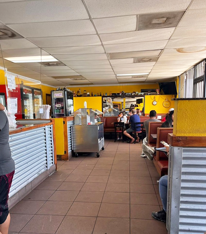 A glimpse into taco paradise where strangers become friends united by their love of authentic Mexican street food. The yellow walls practically radiate happiness.