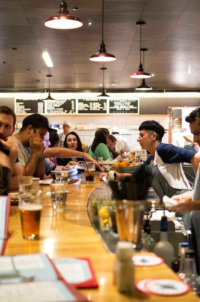 The counter seating isn't just efficient—it's dinner and a show. Watch the kitchen ballet while enjoying the fruits of their labor. Community dining at its finest.