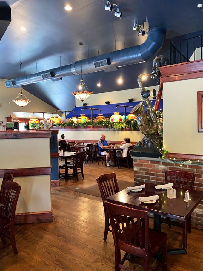 High ceilings with exposed ductwork create a spacious feel, while colorful Tiffany-style lamps add warmth to every dining corner.