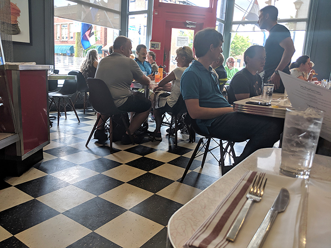 The checkered floor provides the perfect backdrop for what really matters here: people coming together over food worth talking about.