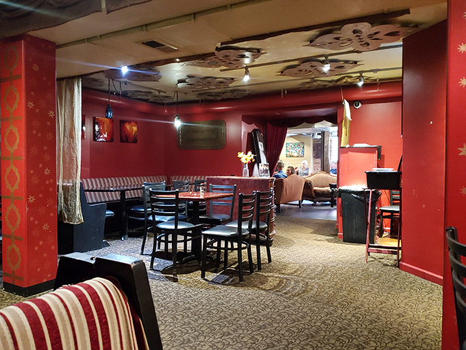 The red room beckons with its dramatic walls and eclectic ceiling art. Like dining in a bohemian jewelry box with tables.