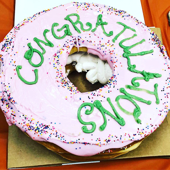 "Congratulations" never looked so delicious. This celebratory donut cake proves that life's milestones should always be frosted and sprinkled.