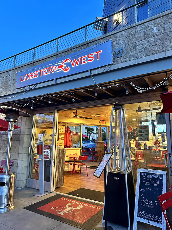 As evening approaches, the welcoming glow of Lobster West beckons seafood lovers. The "Happy with your claws" doormat sets the tone for the experience ahead.
