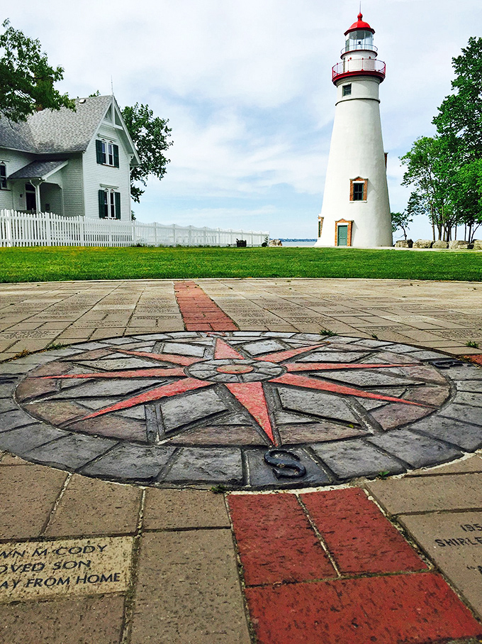 This intricate compass rose embedded in stone points the way to adventure, with the lighthouse standing guard in the background.