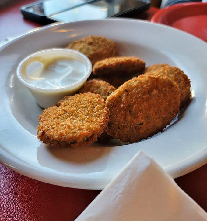 Fried zucchini discs that make eating vegetables feel like cheating. The golden coating shatters with each bite, revealing tender green goodness within.