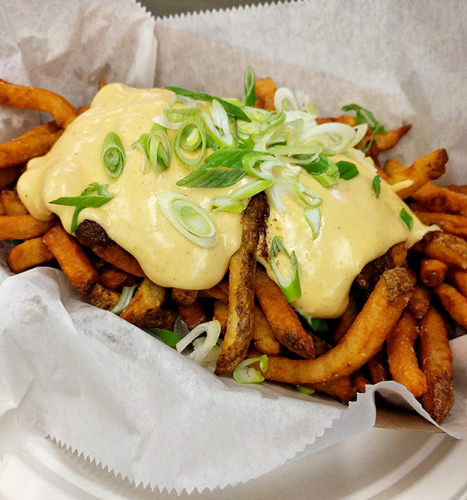 These hand-cut fries, blanketed in cheese sauce and scattered with scallions, make a compelling case for forks at a finger food establishment.