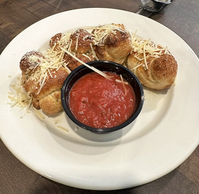 Garlic knots dusted with Parmesan and served with marinara&mdash;simple pleasures that make you question why bread needs to be any more complicated than this.