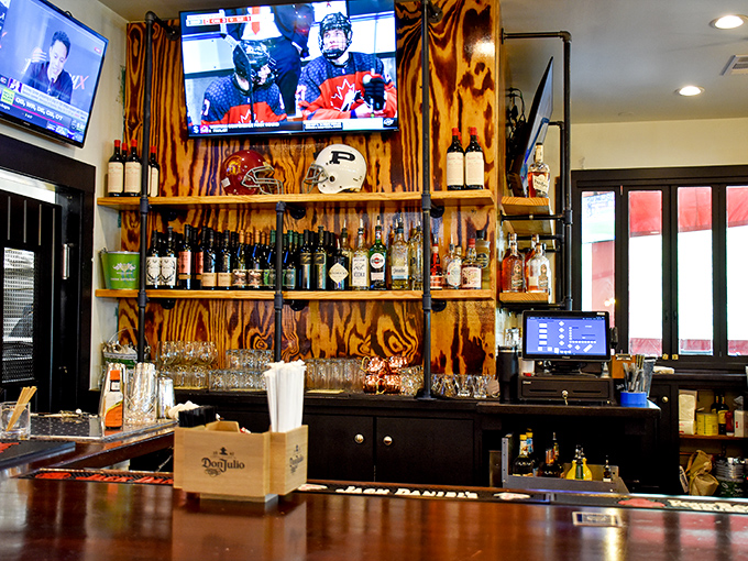 A liquor display that serves as both practical storage and art installation, with bottles arranged like soldiers ready for cocktail duty.