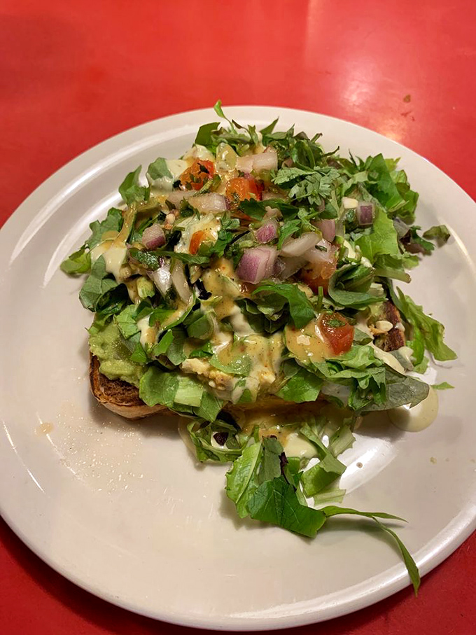 This isn't just toast&mdash;it's a canvas. The chef has painted a masterpiece with fresh greens, vibrant tomatoes, and creamy sauce.