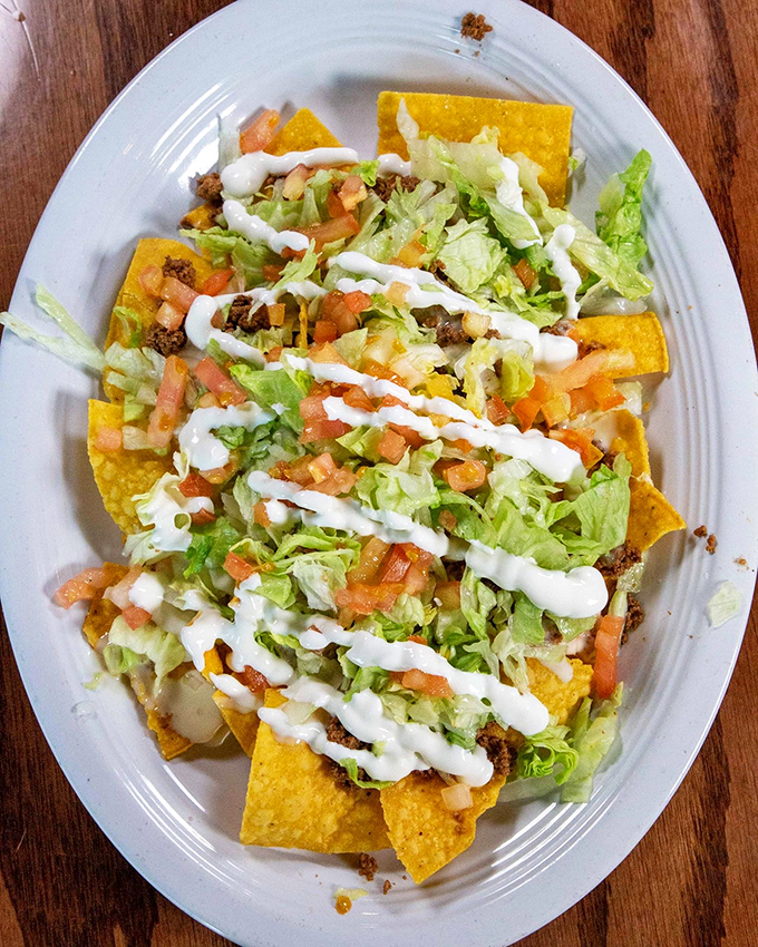 These aren't your ballpark nachos. Crisp tortilla chips layered with seasoned meat, fresh veggies, and zigzags of crema that would make Jackson Pollock proud.