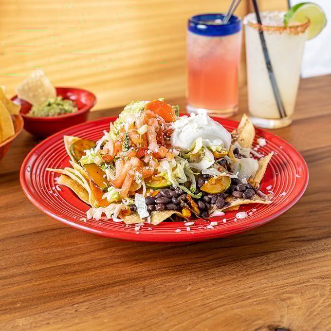 Nachos that require a strategy session before eating. This mountain of toppings transforms humble tortilla chips into a choose-your-own-adventure of flavors.