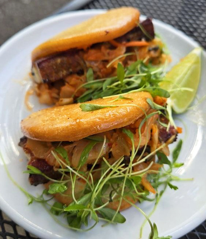 These bao buns cradle pork belly like it's precious cargo, topped with microgreens that add both color and conscience to indulgence.
