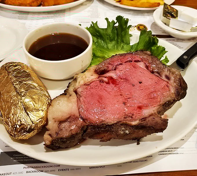 Prime rib cooked to that perfect shade of pink that makes carnivores weak at the knees. That baked potato in foil is the unsung sidekick.