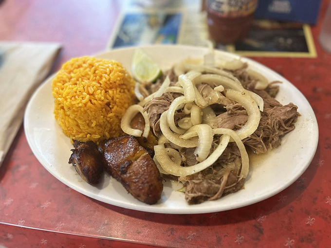 Puerco asado with its crown of onions and golden rice sidekick. This isn't just dinner—it's a celebration on a plate that makes everyday feel like Sunday.