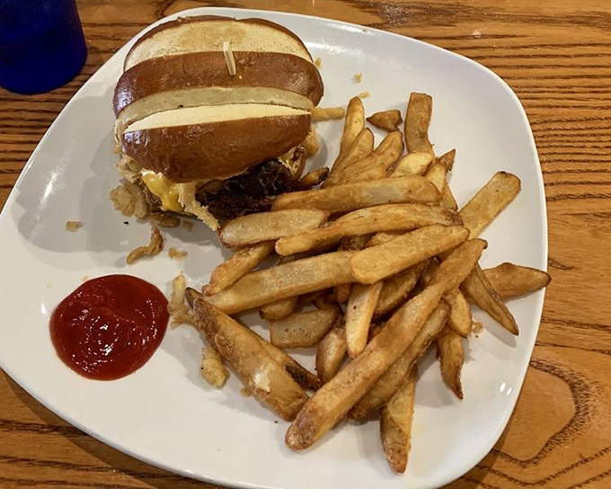 A sandwich that requires both hands and your full attention&mdash;the pulled pork nestled in that pretzel bun isn't just food, it's an event.