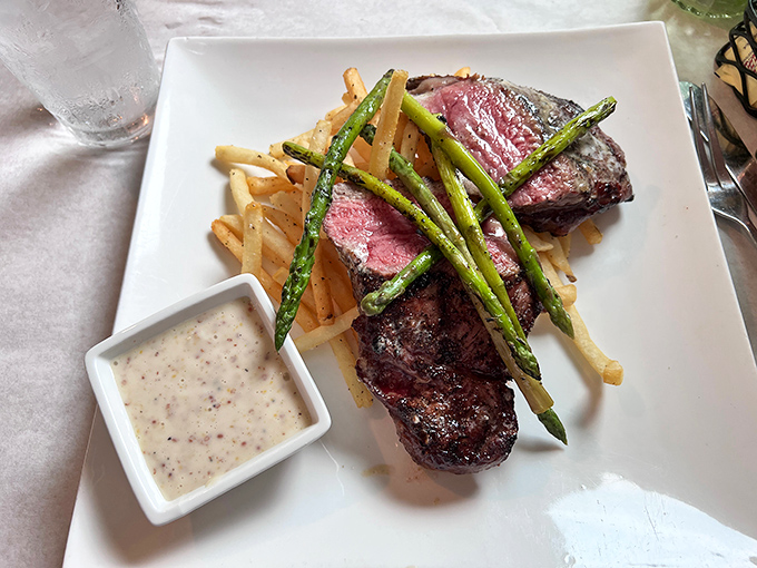 This steak isn't just cooked—it's respected. The asparagus stands at attention while the sauce waits patiently in its ramekin for its moment of glory.