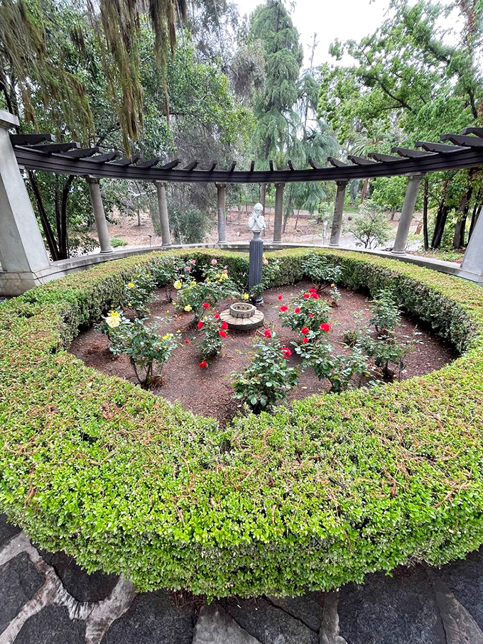 This perfectly manicured rose garden surrounded by columns proves that geometric precision and natural beauty can coexist in spectacular harmony.