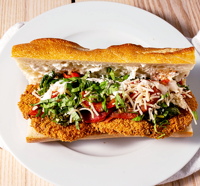 This sandwich isn't messing around—crispy, saucy, and layered with enough toppings to require an engineering degree to eat properly.