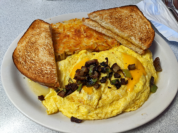 This omelet doesn't just contain vegetables; it showcases them in a fluffy egg gallery where mushrooms and peppers are the stars of the show.