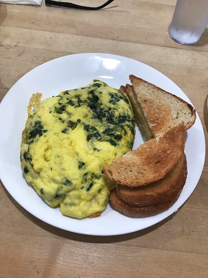 A spinach and cheese omelet that puts ordinary egg dishes to shame, paired with toast that's actually worthy of the accompanying butter.