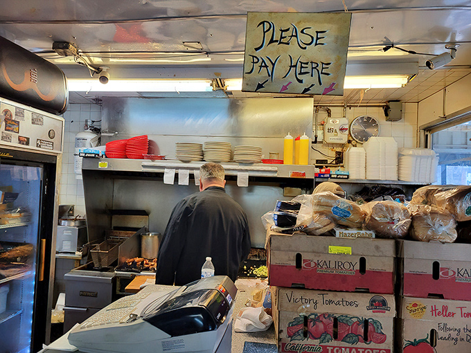The kitchen&mdash;where the magic happens. That handwritten "Please Pay Here" sign has probably witnessed more late-night confessions than a bartender.