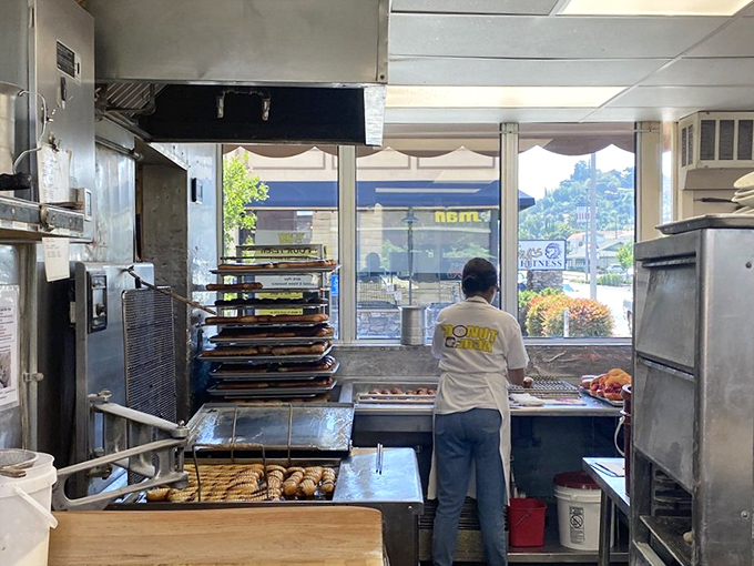 Behind the scenes, skilled hands craft each donut with precision and care, maintaining traditions that have made this shop legendary.