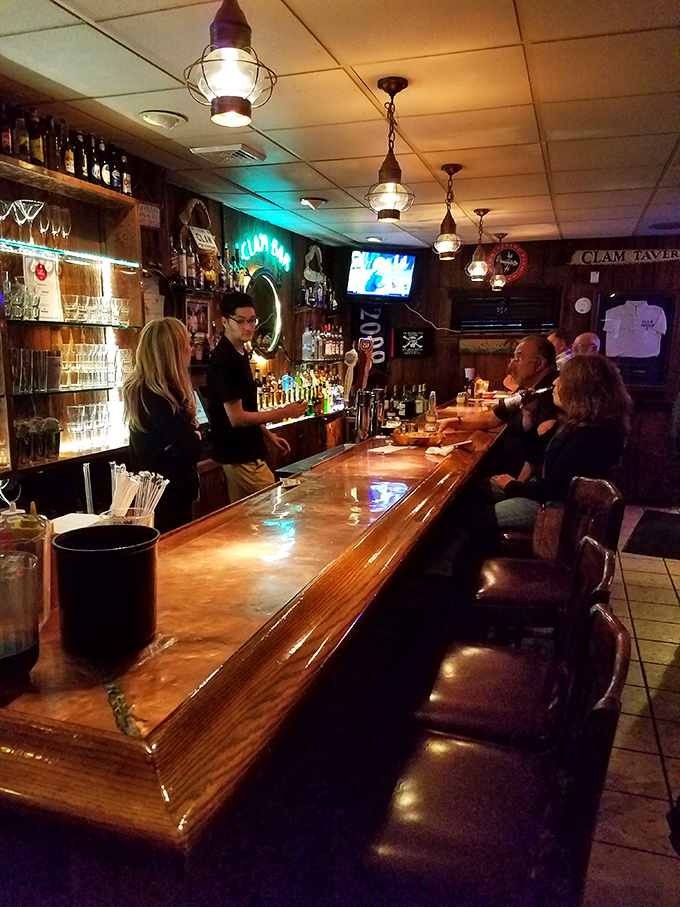 The bar area glows with maritime charm, where nautical lighting fixtures cast a warm glow over conversations and cold drinks.