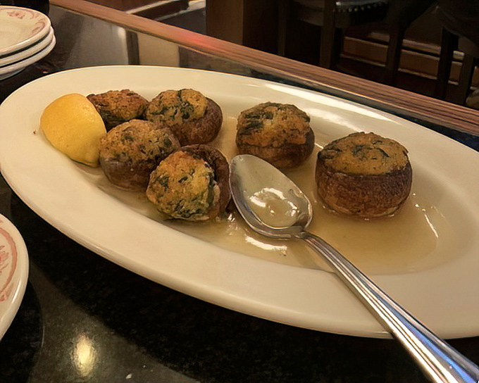 Stuffed mushrooms that make vegetable skeptics reconsider their life choices—golden, herby, and swimming in a sauce worth bottling.