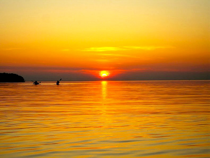 Sunsets so spectacular they should charge admission. The golden finale that turns kayakers into silhouettes against nature's nightly masterpiece.