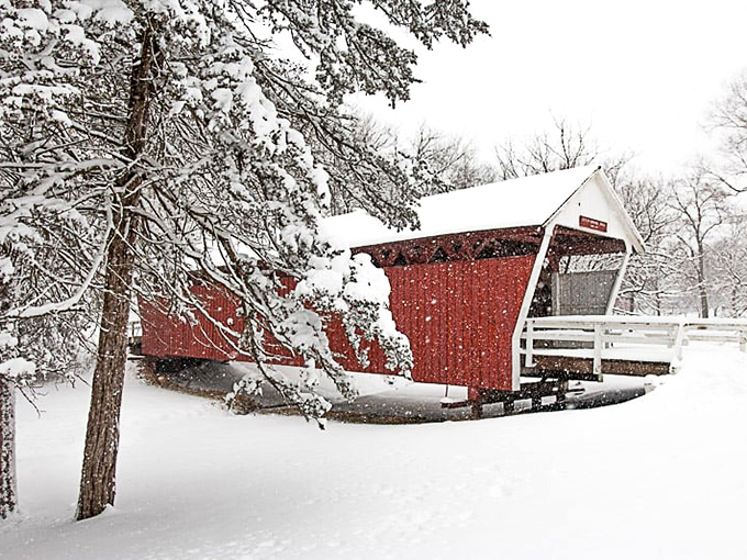 Winter blankets a covered bridge in pristine snow, creating a Christmas card scene that makes even the coldest day seem magical.