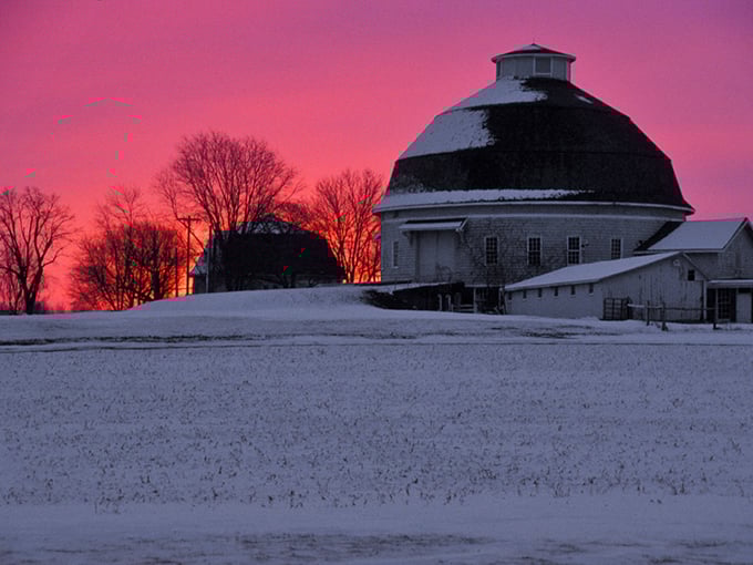 Even in winter's embrace, Mount Carroll's iconic round barn stands as a testament to agricultural ingenuity against a dramatic pink sky.