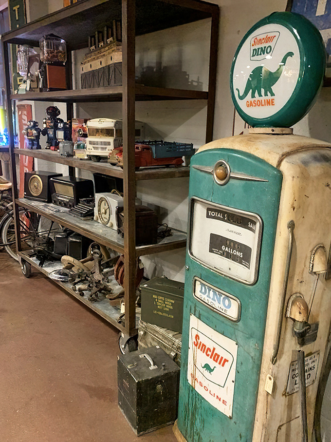 The Sinclair Dino gas pump stands sentinel beside shelves of vintage toys, a petroleum-age relic that once fueled family road trips across America's expanding highways.