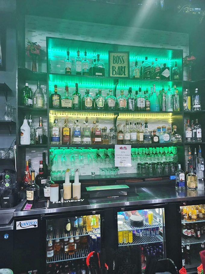 The bar area glows with emerald ambiance, promising libations that complement rather than compete with the soulful menu.
