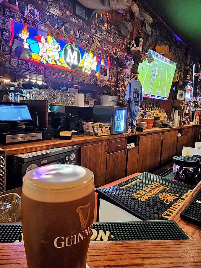 Behind the bar, Guinness pours properly while international flags celebrate the pub's welcoming global spirit.