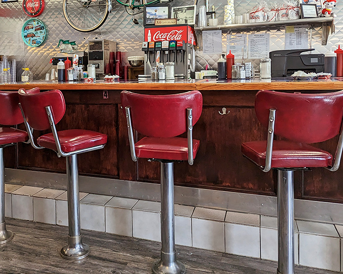 The soda fountain and counter setup hasn't changed since Buddy Holly topped the charts. Those red stools have heard more town gossip than any therapist in Massachusetts.