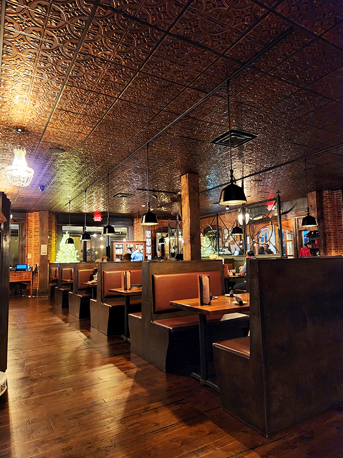 These booths aren't just seating—they're personal dining sanctuaries beneath a stunning pressed-tin ceiling that reflects decades of culinary tradition.