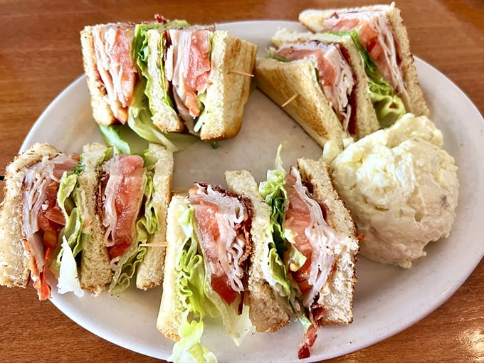 Club sandwich architecture that defies gravity. Those toothpicks aren't decorative&mdash;they're structural support for this tower of deliciousness.