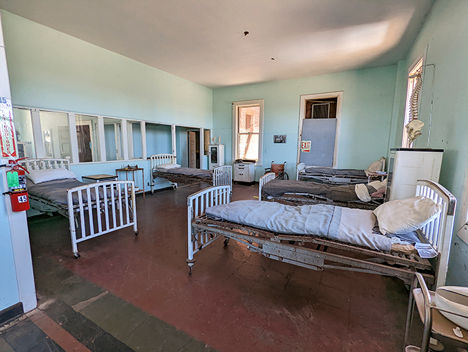 The mint-green walls of this medical ward offer a false cheerfulness, the antique hospital beds standing as relics of healthcare practices long since evolved.