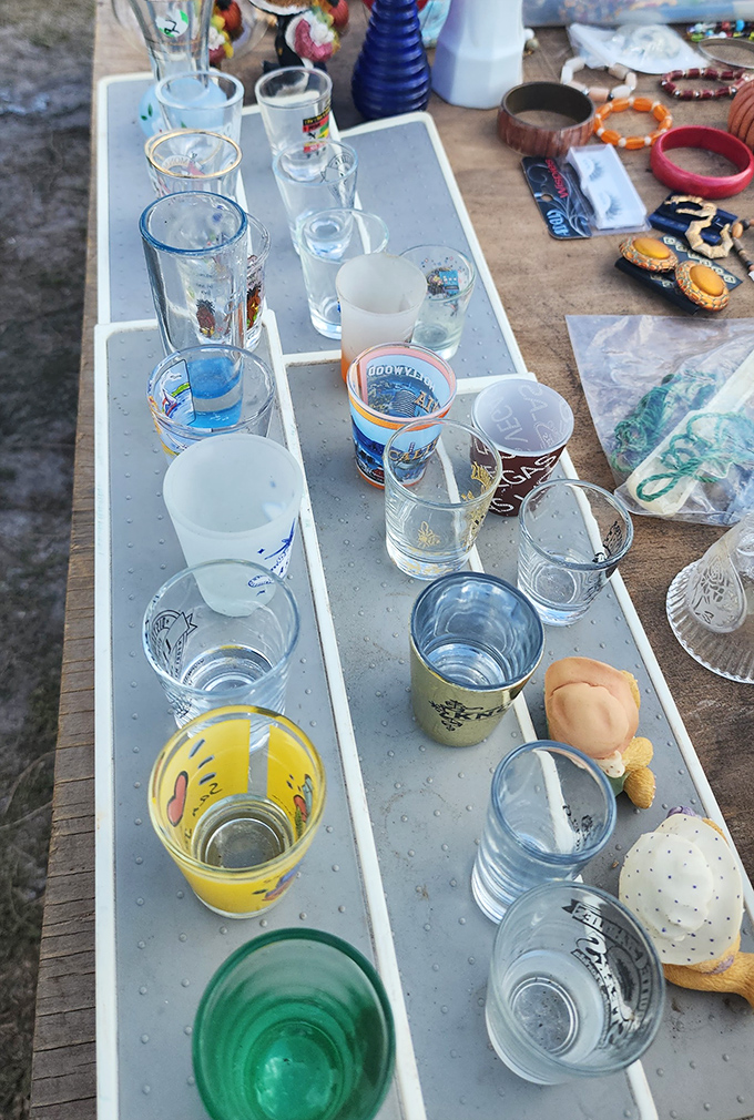 Vintage glassware lined up like liquid history. That yellow smiley face tumbler probably served everything from Kool-Aid to something considerably stronger.