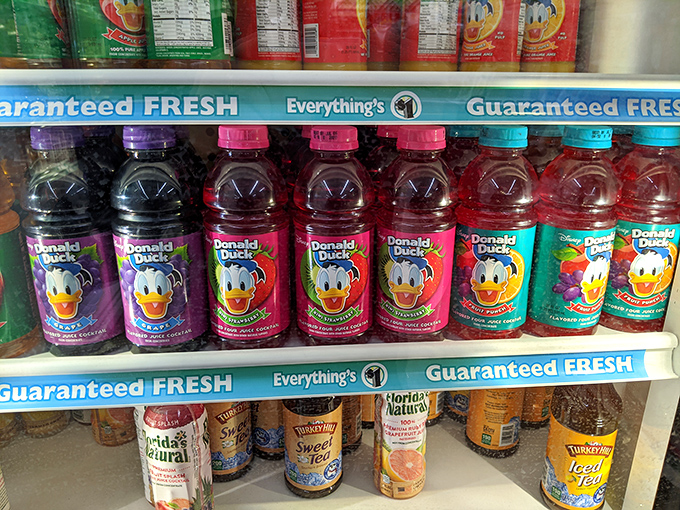 Donald Duck juice bottles lined up like cartoon celebrities at a liquid premiere. Childhood nostalgia meets adult thirst-quenching in vibrant technicolor.