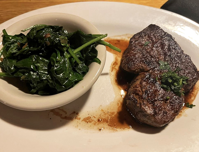Filet mignon arrives tender enough to cut with a fork, accompanied by vibrant saut&eacute;ed spinach.