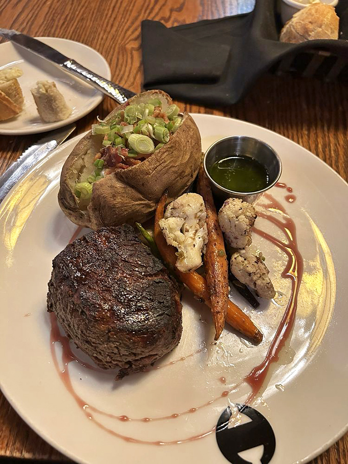 A filet that could convert vegans, accompanied by a loaded baked potato that's dressed better than most people at fancy restaurants.